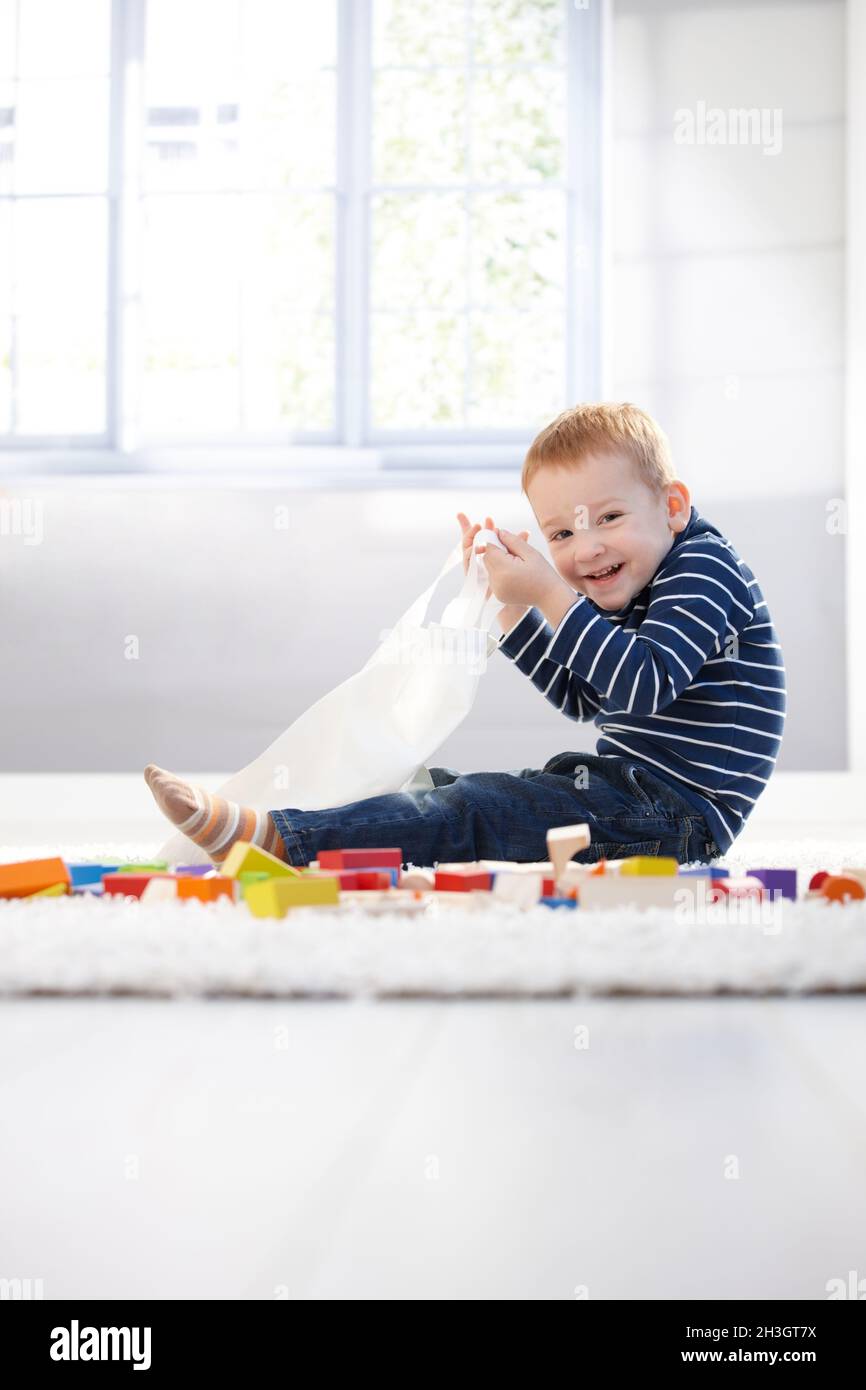 Happy little boy playing on floor Stock Photo - Alamy
