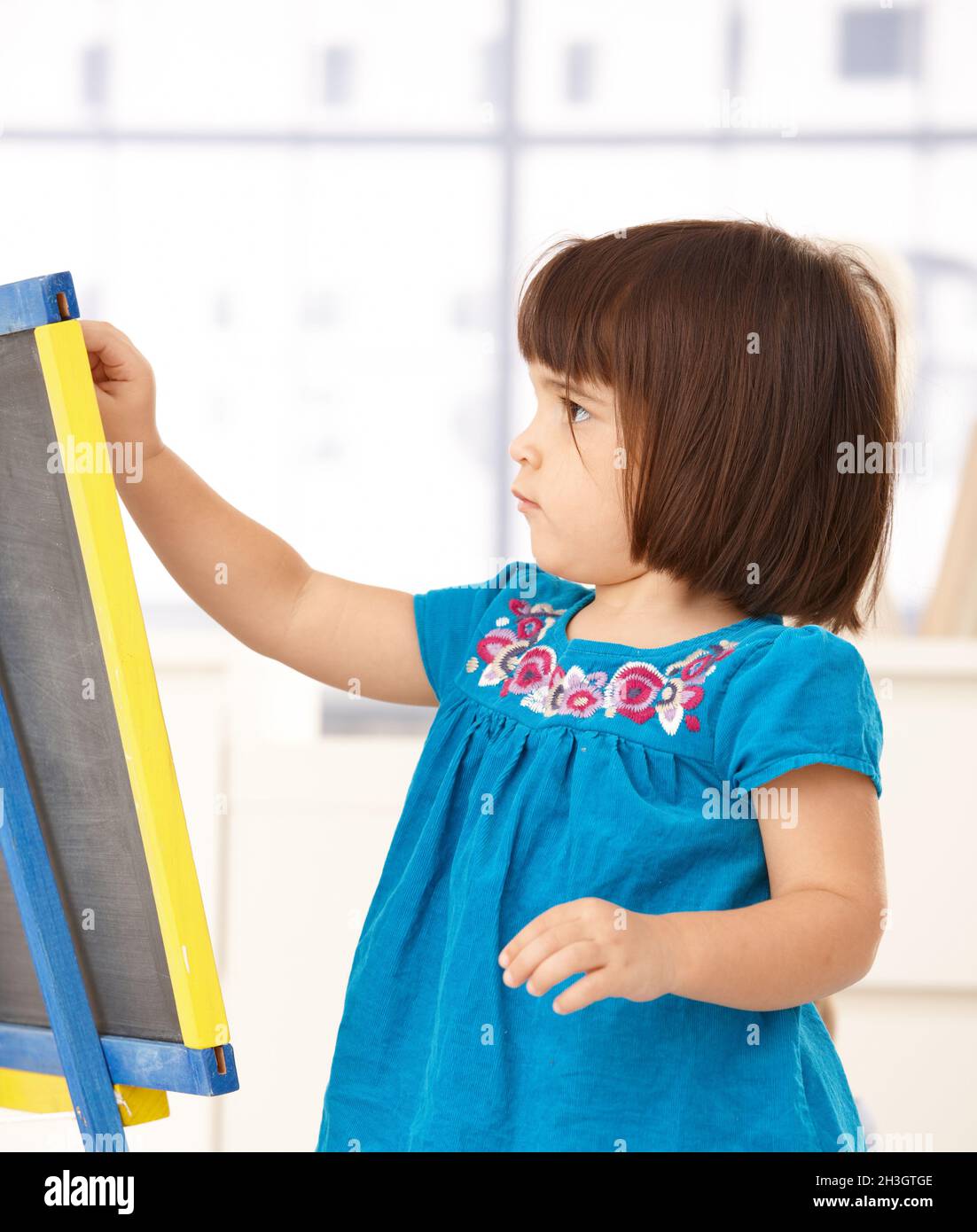 Cute little girl with drawing board Stock Photo - Alamy