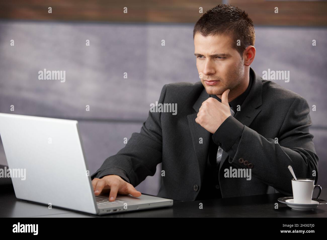 Young businessman using laptop in office Stock Photo - Alamy