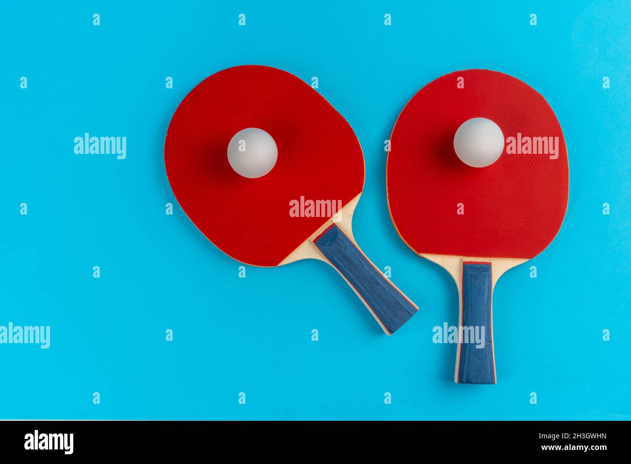 Red ping pong racket on a blue background Stock Photo - Alamy