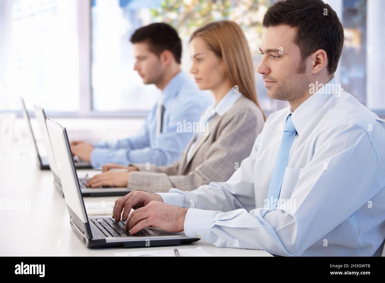 Young people working on laptop in meeting room Stock Photo - Alamy