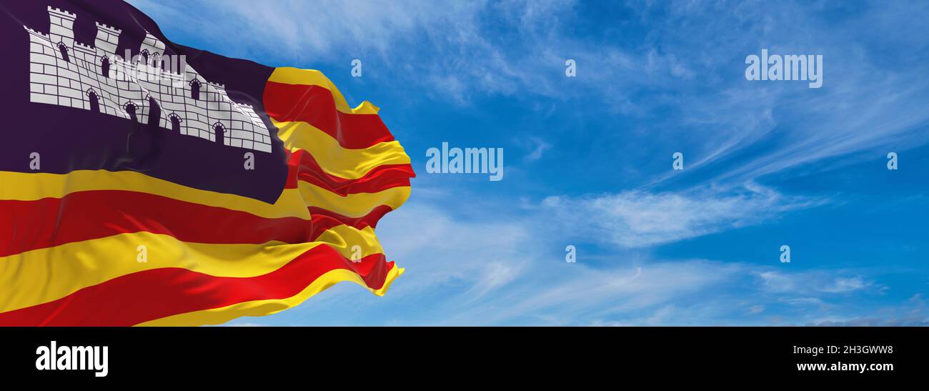 flag of Balearic Islands , Spain at cloudy sky background on sunset ...