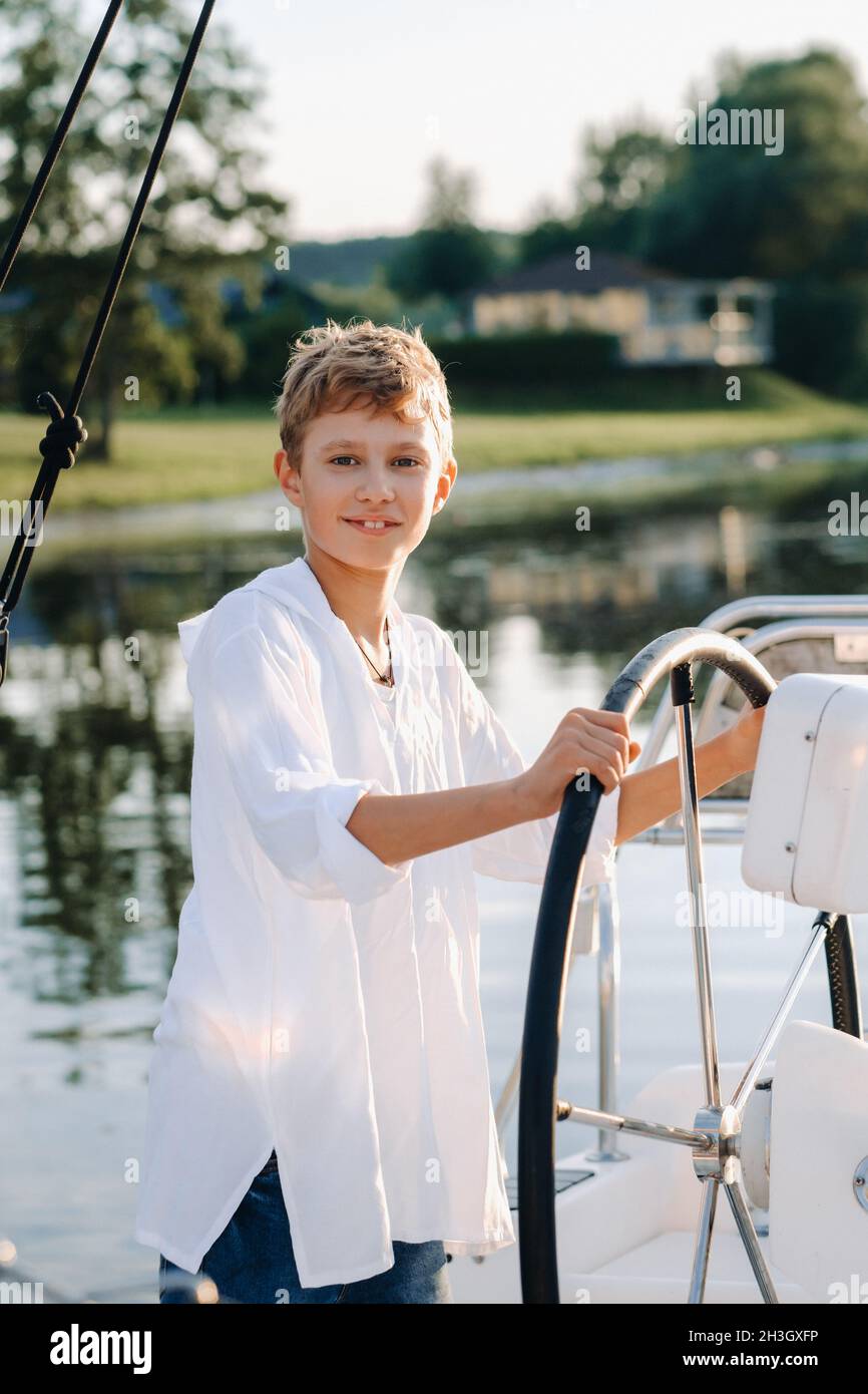 a little captain at the helm on a yacht. a little boy at the helm of ...