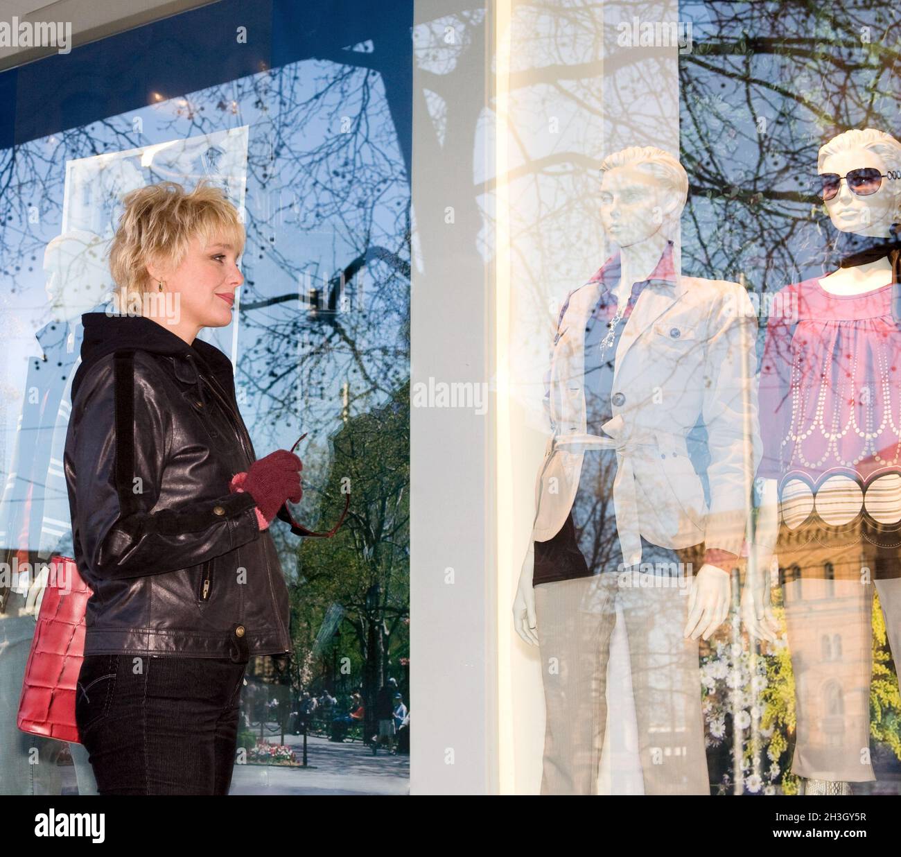 Woman examining a show-window of shop Stock Photo - Alamy