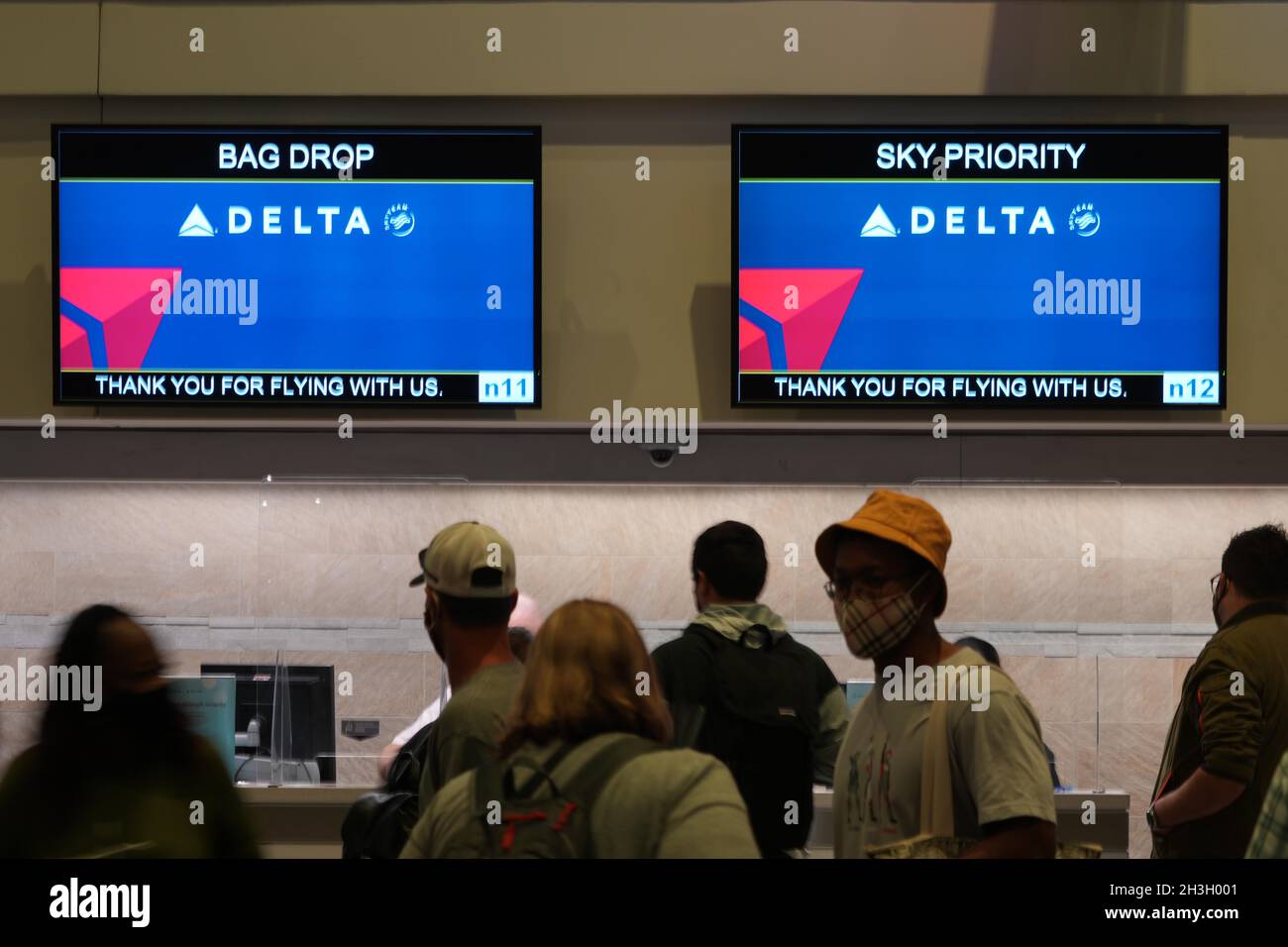 Passengers at Delta Airlines ticket baggage drop counter at the ...