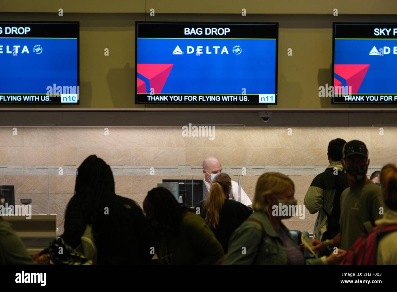 Passengers at Delta Airlines ticket baggage drop counter at the ...