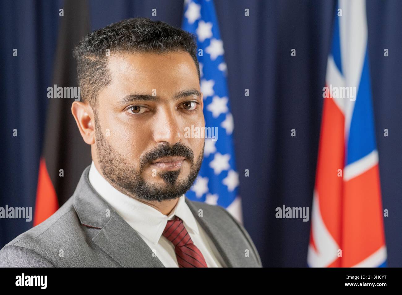 Portrait of serious mixed race bearded politician in suit posing ...
