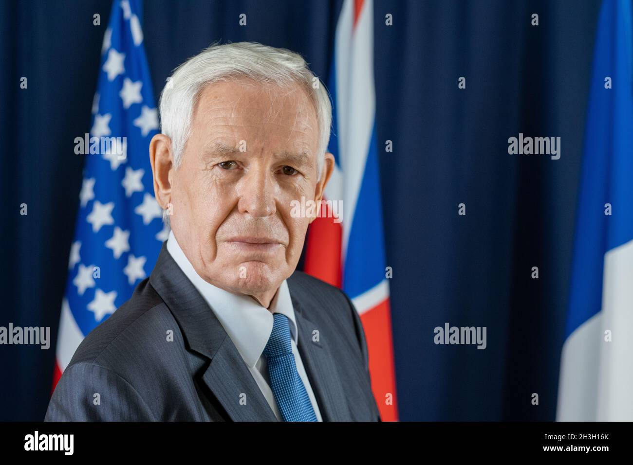 Portrait of serious aged white-haired politician in necktie and formal ...