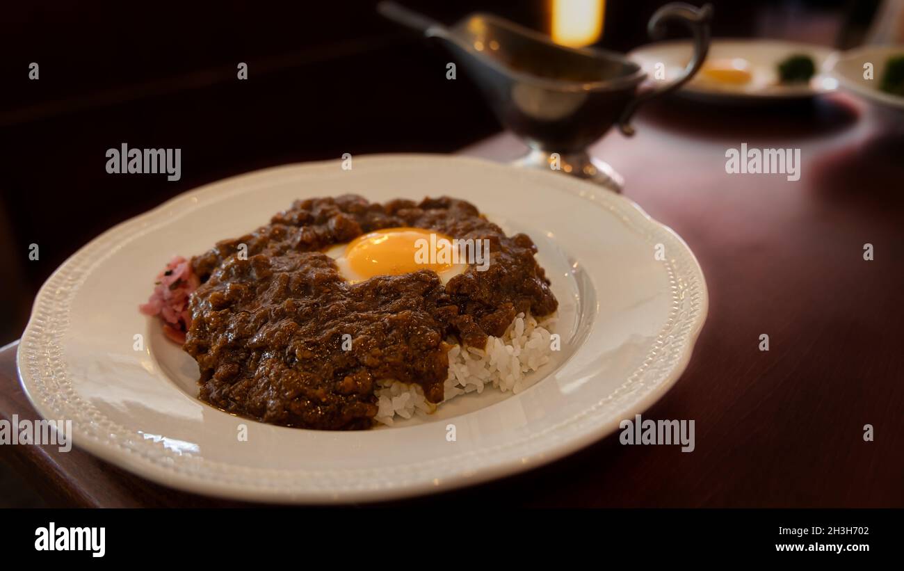 Japanese breakfast, curry with white rice and an egg served sunny side ...