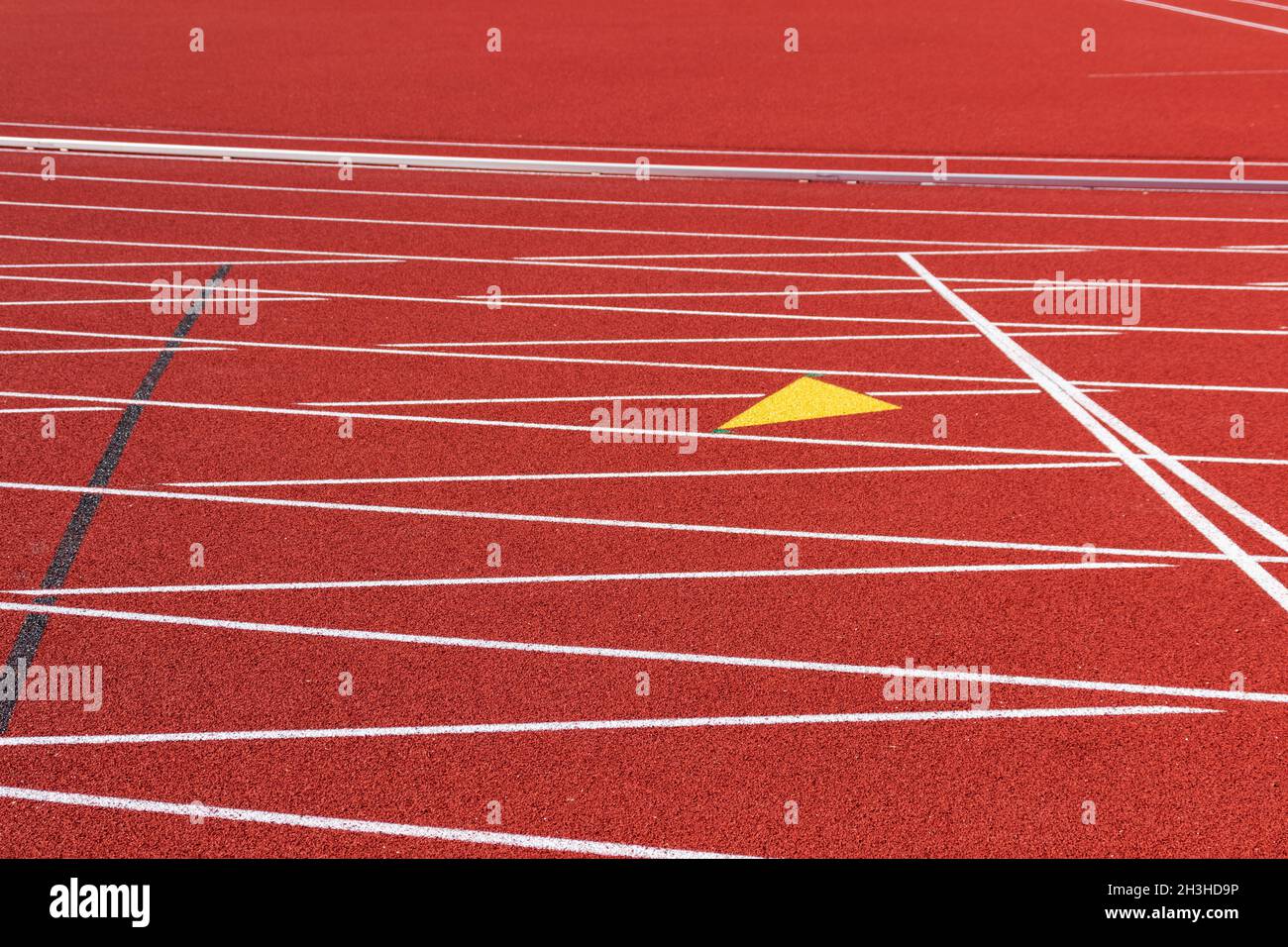 White lines, yellow triangle on the curve of all weather rubber running ...