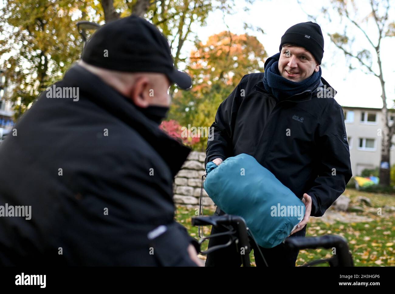 Berlin, Germany. 28th Oct, 2021. Social worker Wojciech Greh (r) hands ...