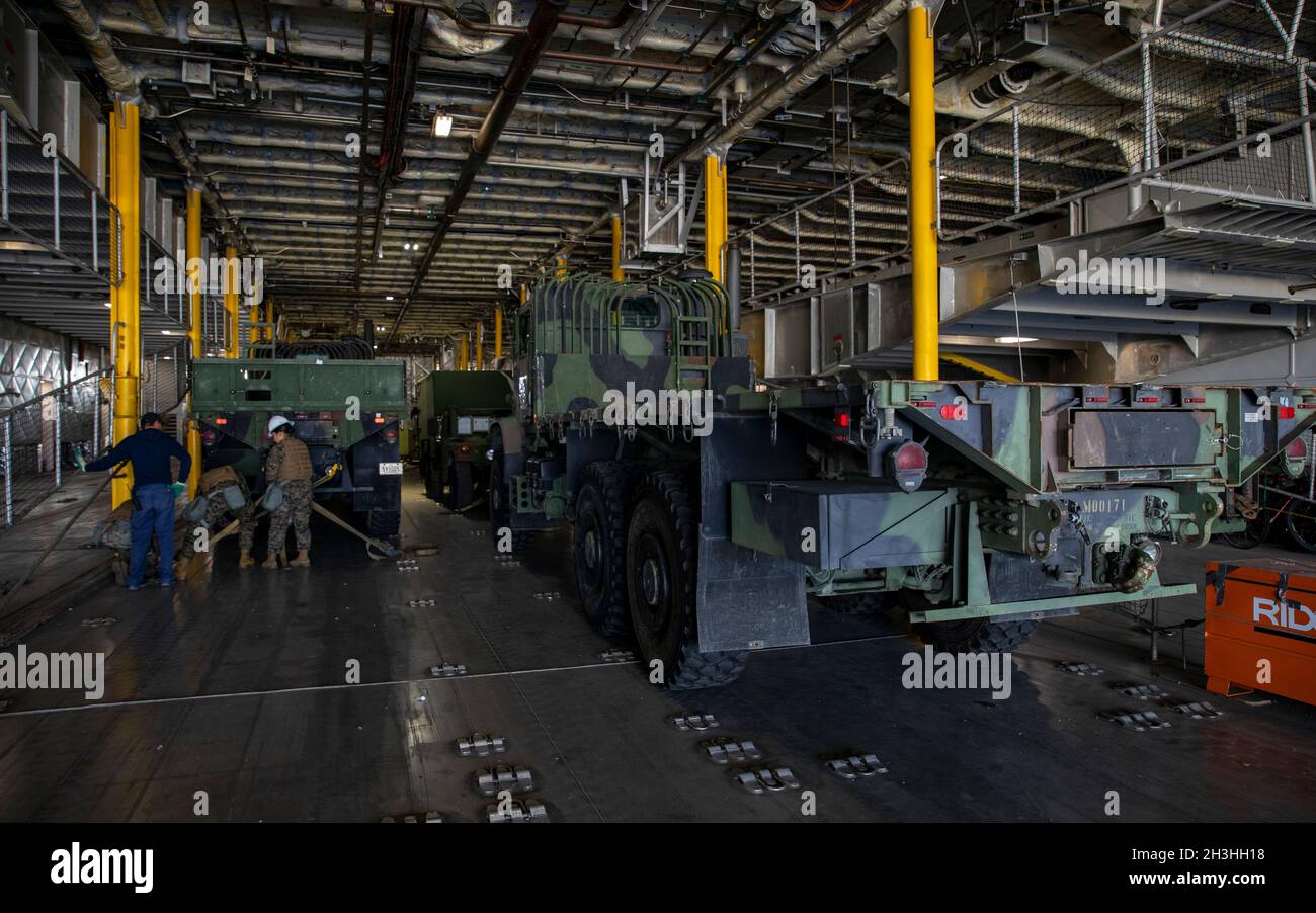 U.S. military vehicles are loaded onto the USNS Guam (T-HST-1) during ...