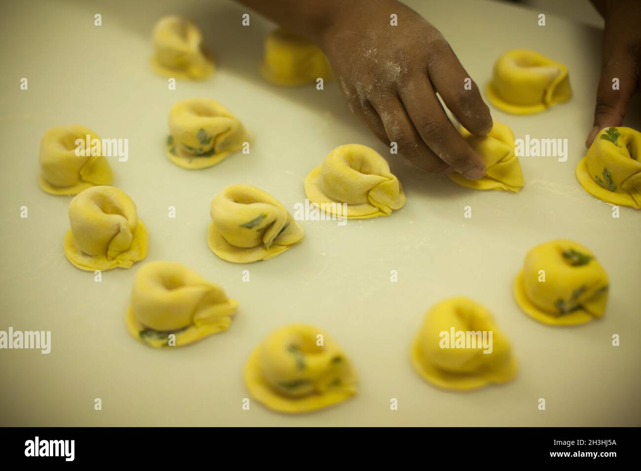 Human Hands making Raw and dry capeletti pasta on kitchen table Stock ...