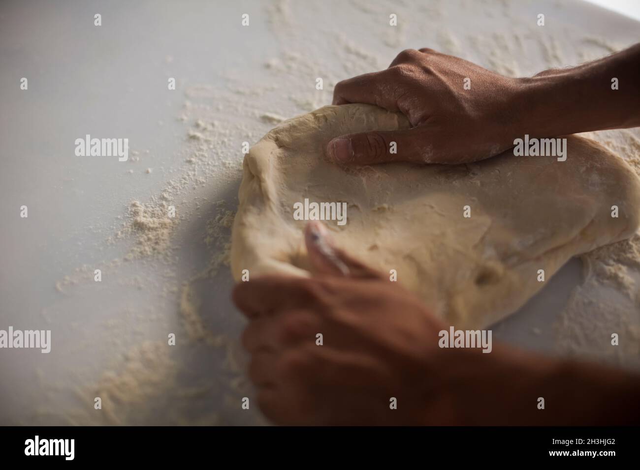 Human Hand making pasta - making Raw and dry pasta on kitchen table ...