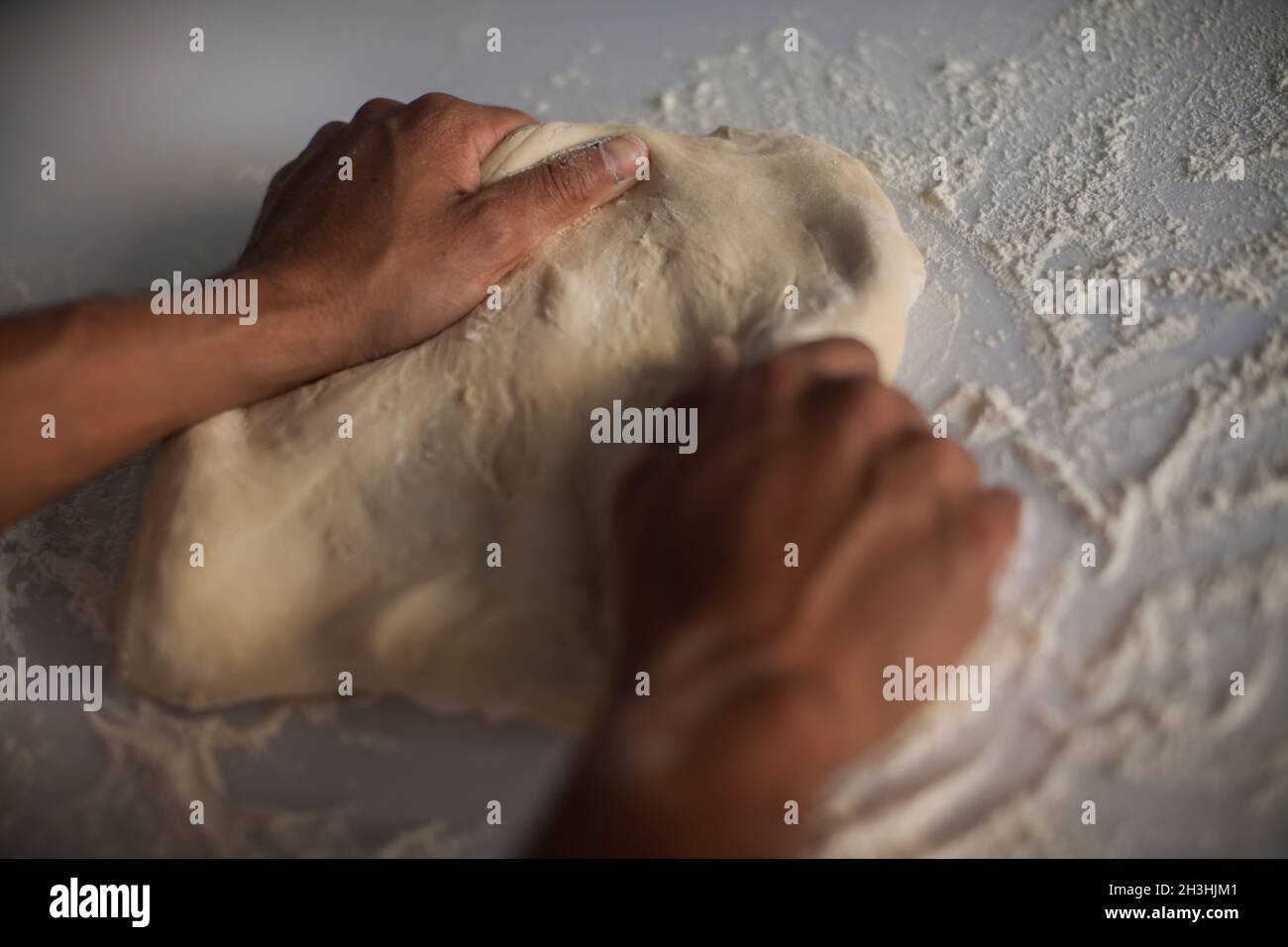 Human Hand making pasta - making Raw and dry pasta on kitchen table ...