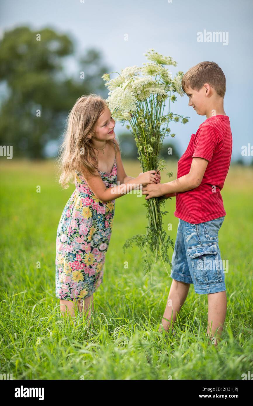 Spring. Boy gives girl a bouquet of flowers Stock Photo - Alamy