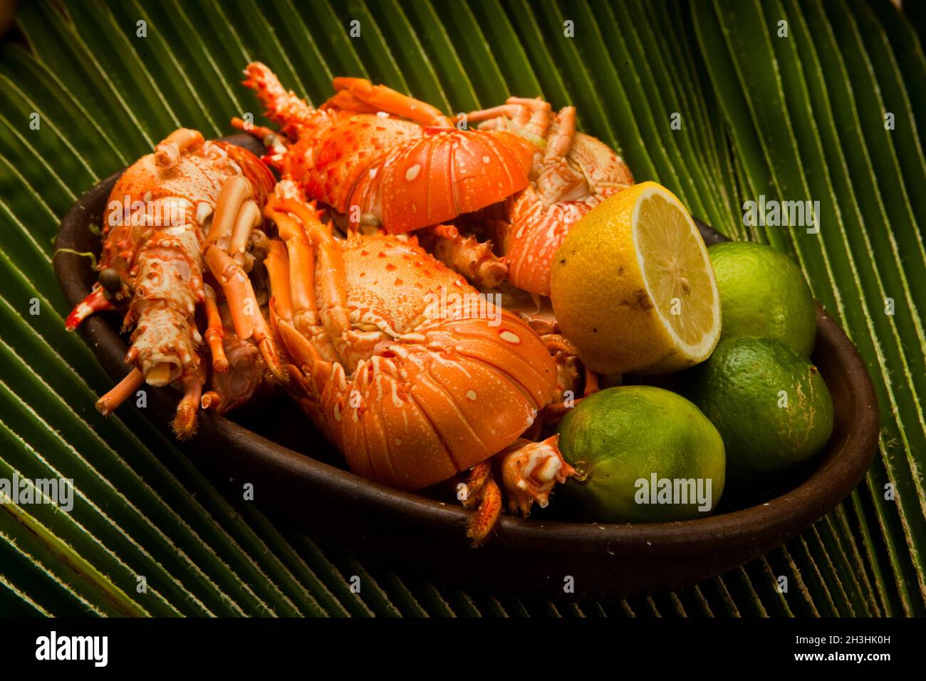 Delicious fresh and cooked whole lobster with lime, lemon on a banana ...