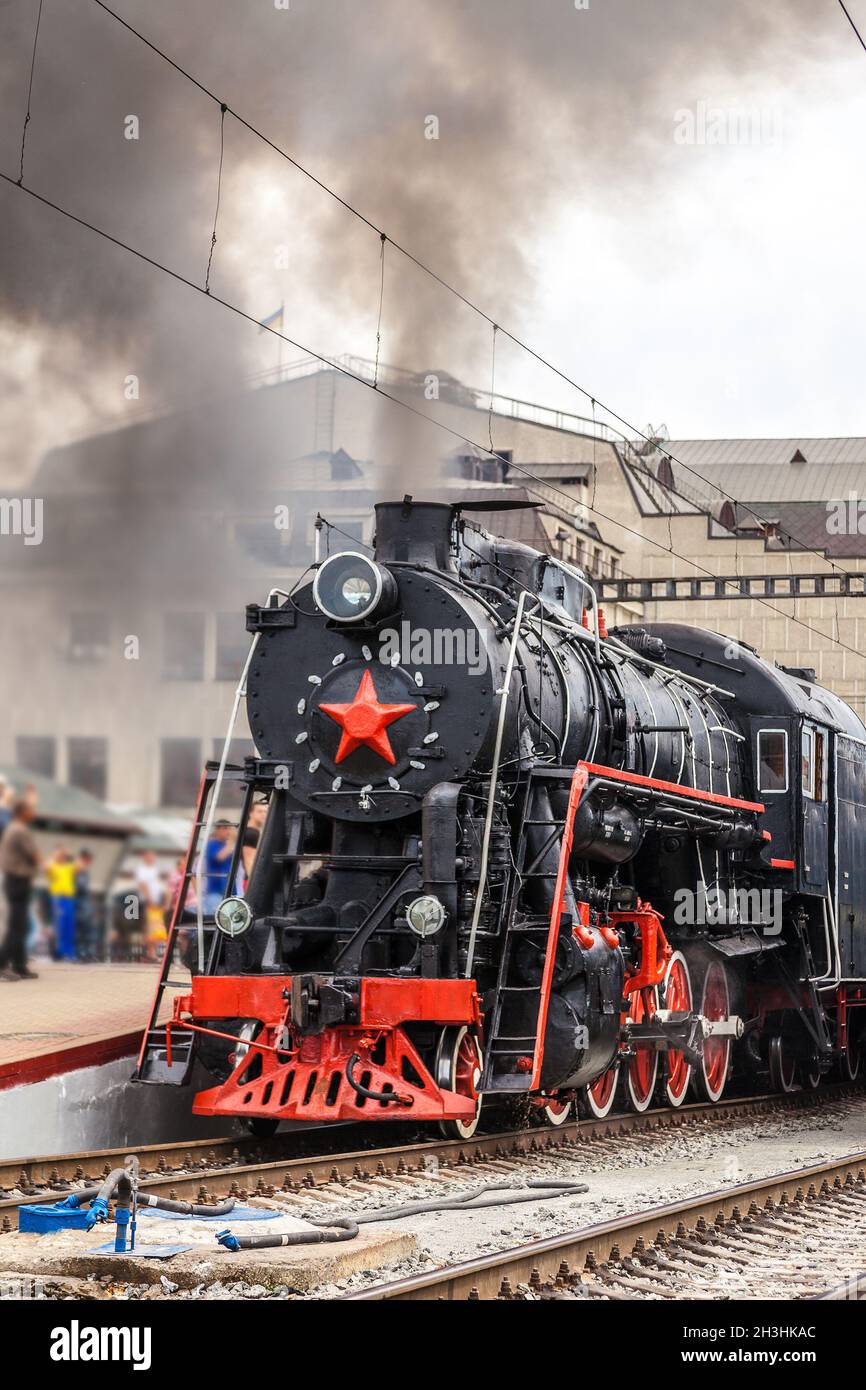 Old steam train is leaving a station Stock Photo - Alamy