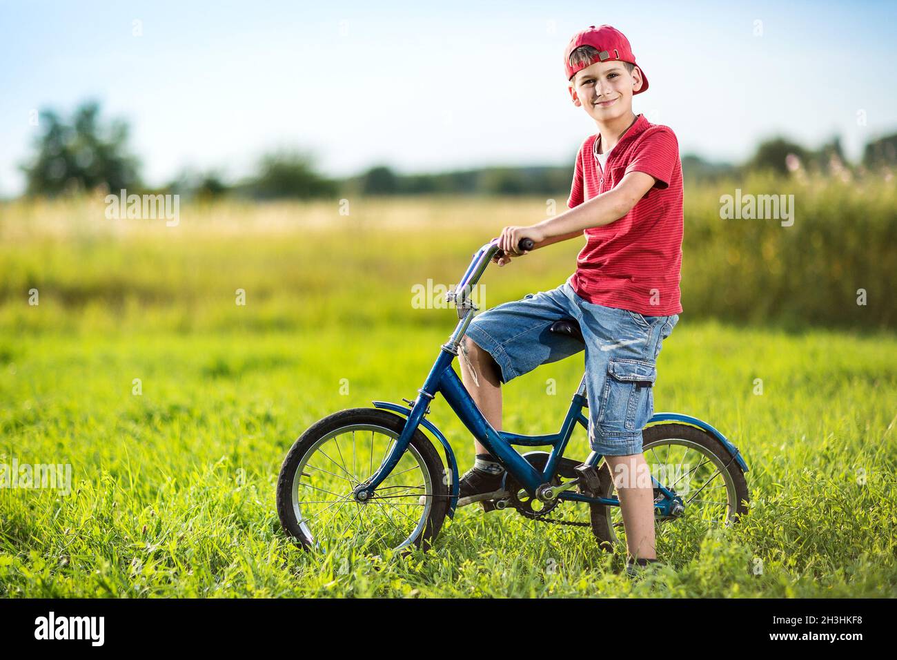 Young boy riding bicycle in a park Stock Photo - Alamy