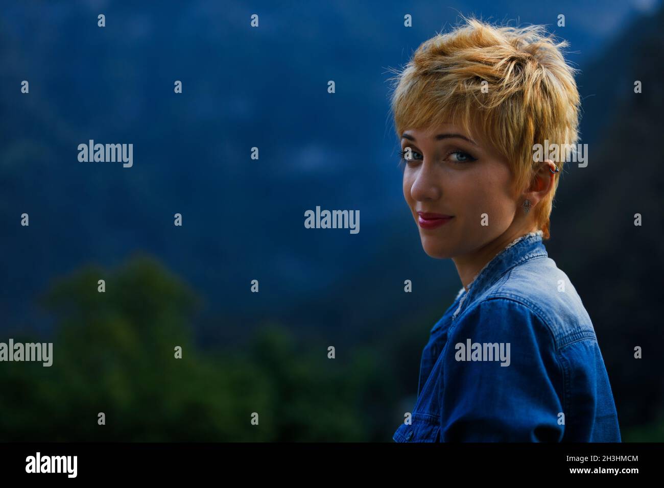 young perplexed woman with short hair, portrait in the mountains ...