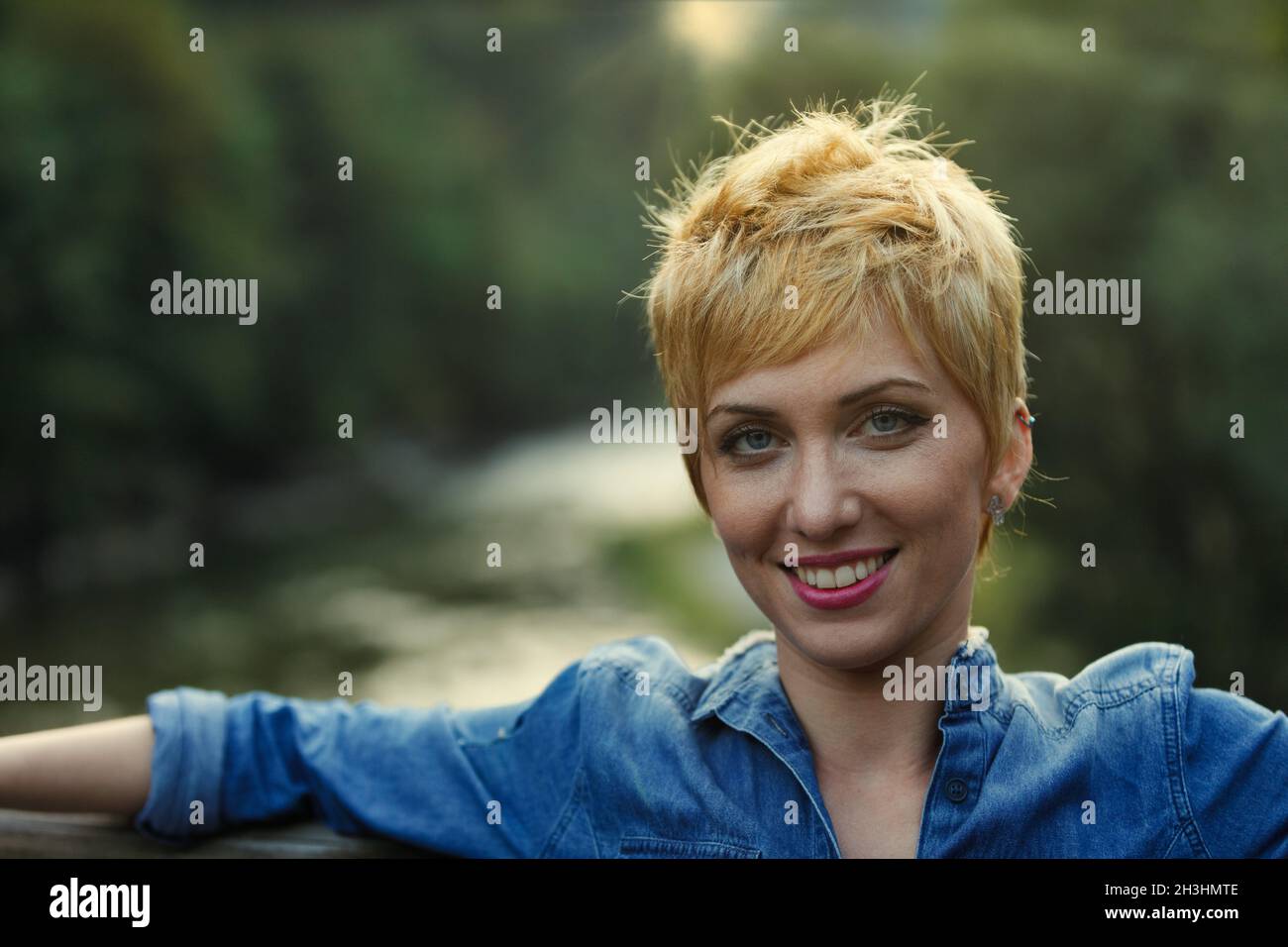 Upper body portrait of smiling young blond woman relaxing in ... Upper body portrait of smiling young blond woman relaxing in ...