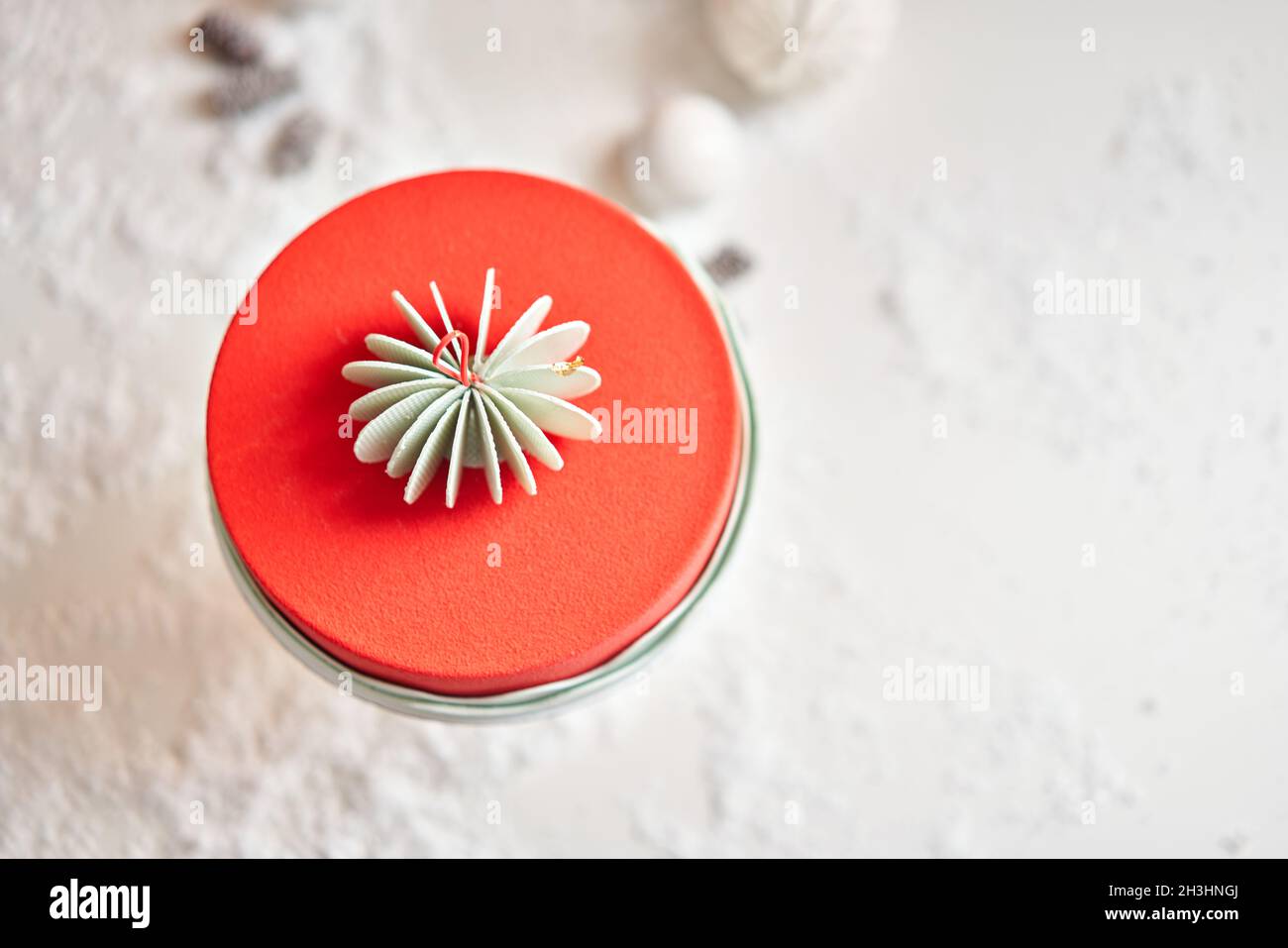 Mousse cake covered with red velour. Dessert on a snow-covered table ...