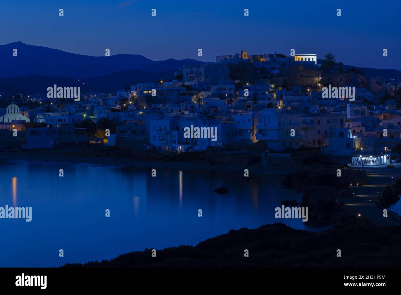 Blue night over a mountainous Greek island with a white city. Street ...