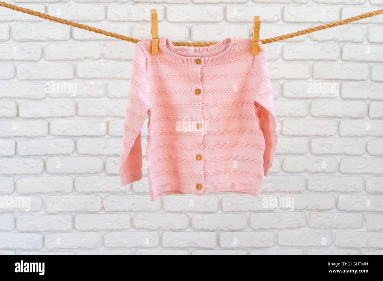 Washing of baby clothes pinned on a rope to dry Stock Photo - Alamy