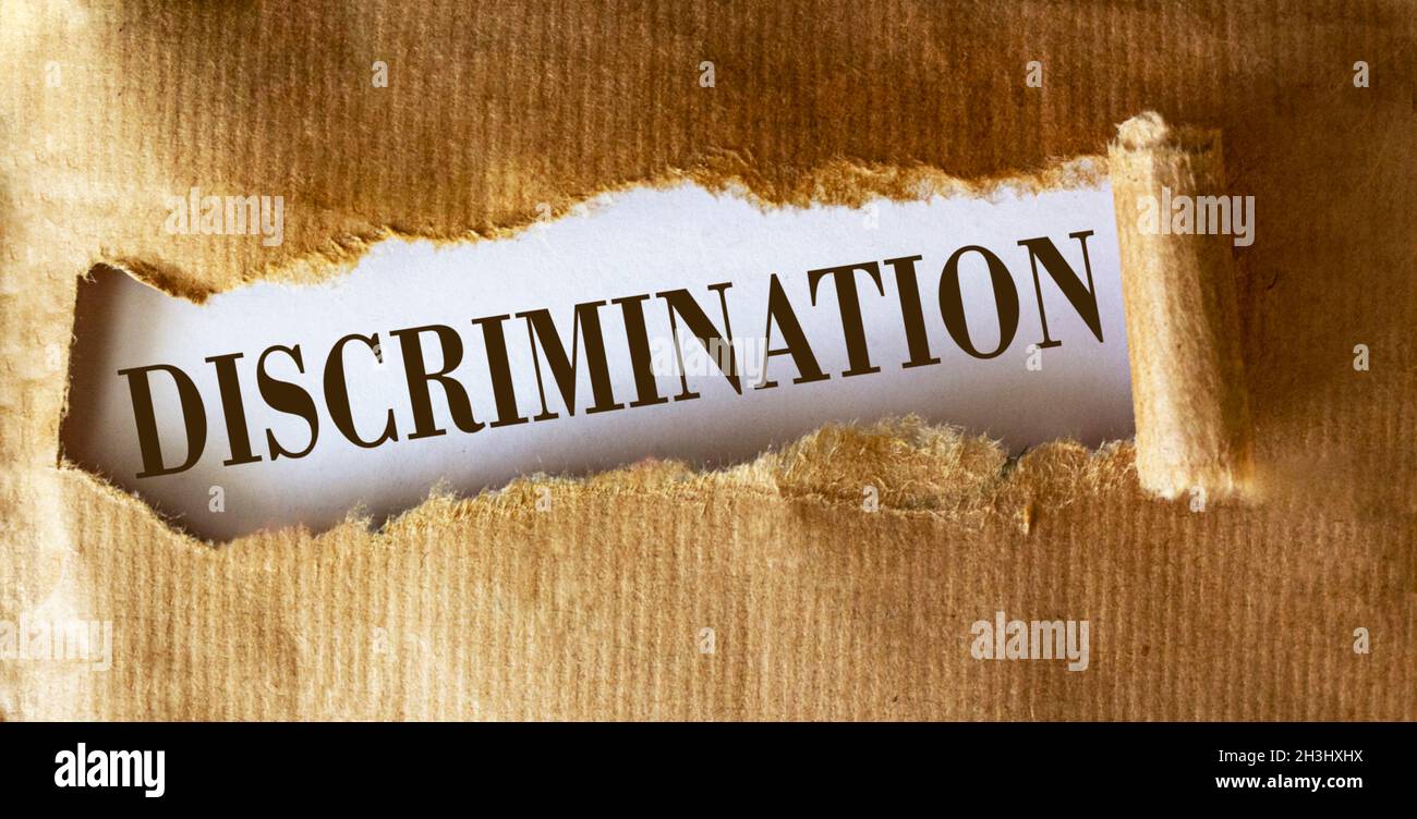 Discrimination is written on torn brown paper. Discrimination concept ...