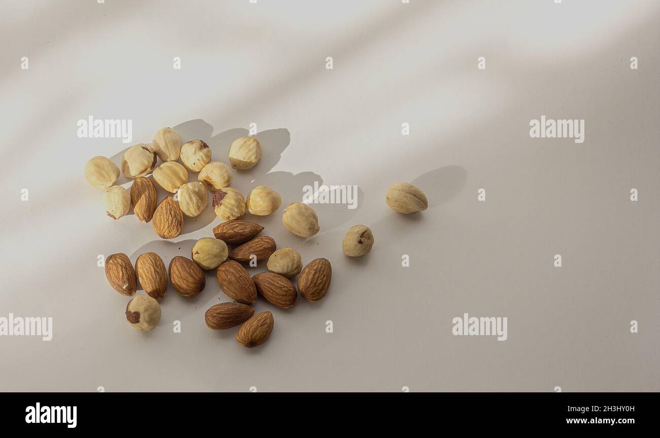 Different nuts on a white background, space for text Stock Photo - Alamy