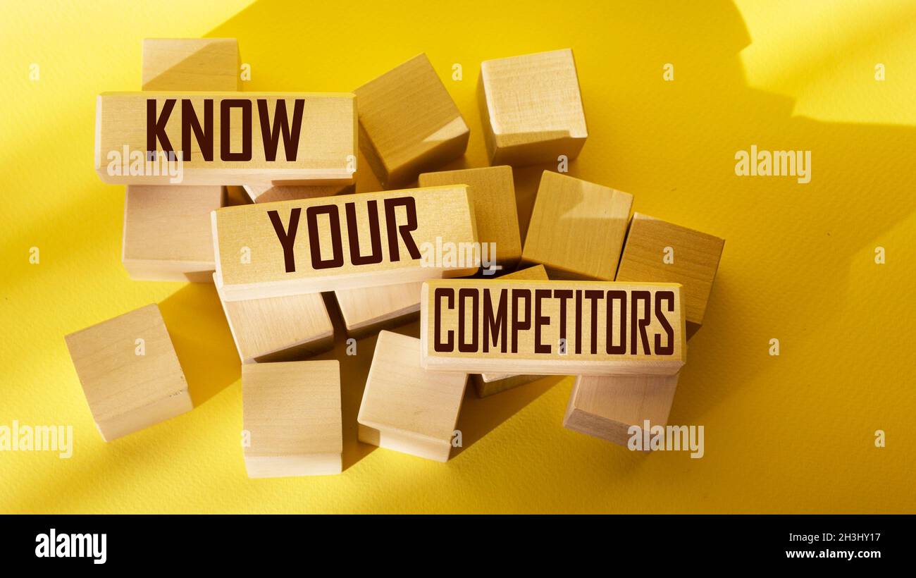 The text KNOW YOUR COMPETITORS is written on wooden blocks and on a ...