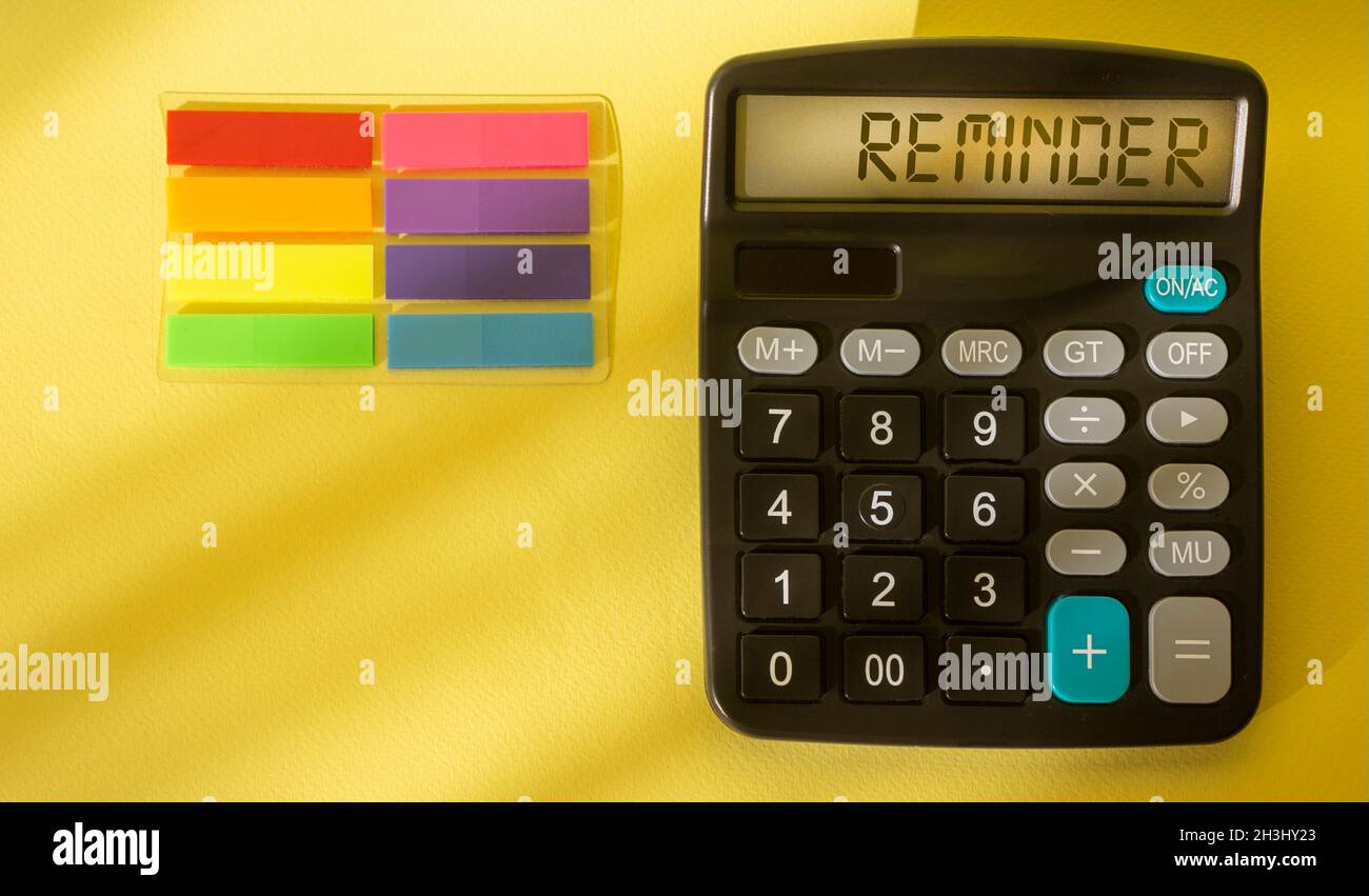 REMINDER text on calculator on yellow sheet with colorful stickers ...