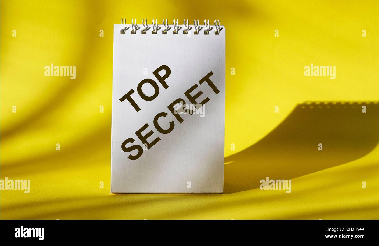 TOP SECRET text on white notepad and yellow background Stock Photo - Alamy