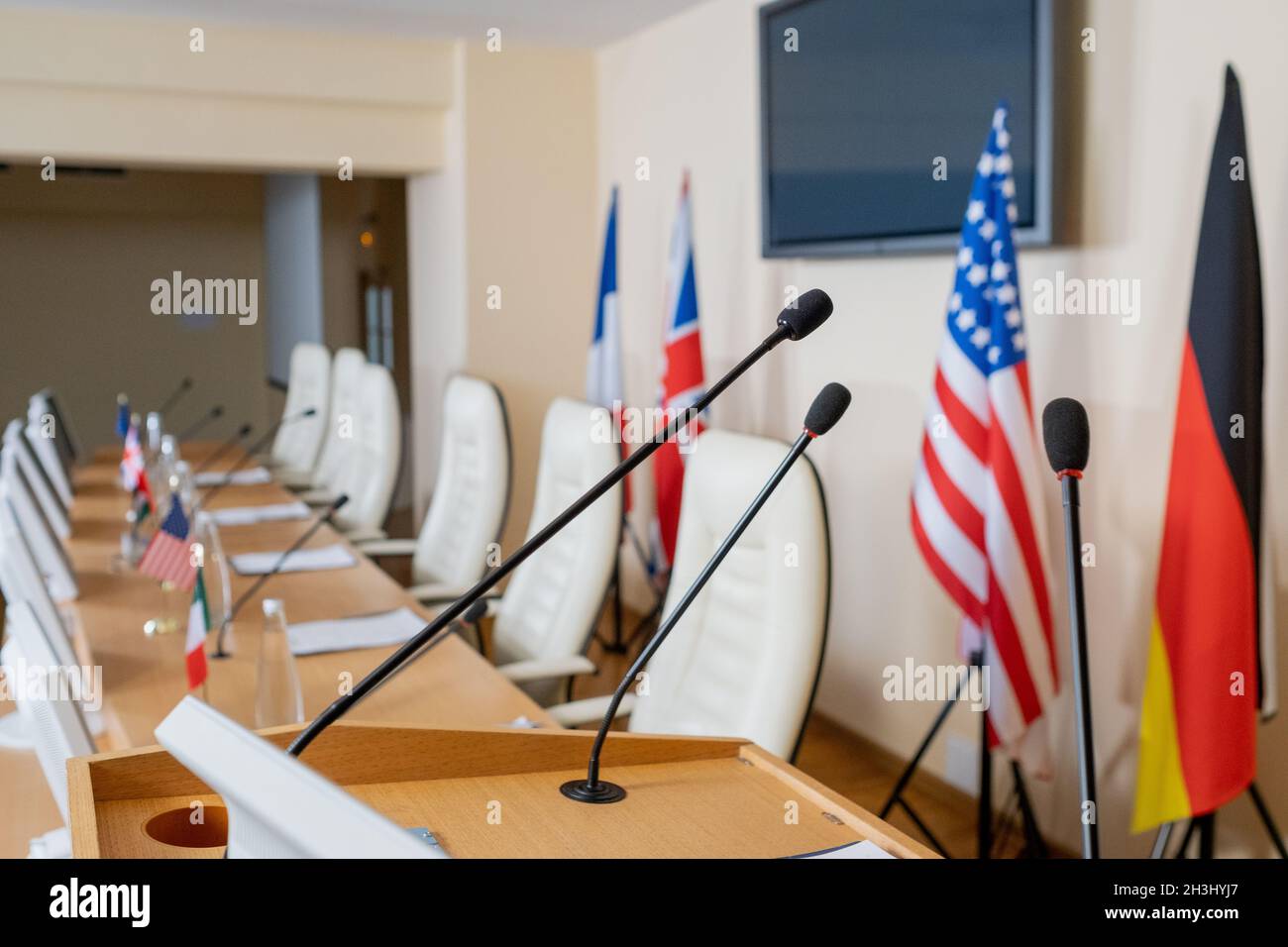 Empty wooden rostrum stand with microphones in conference room with ...