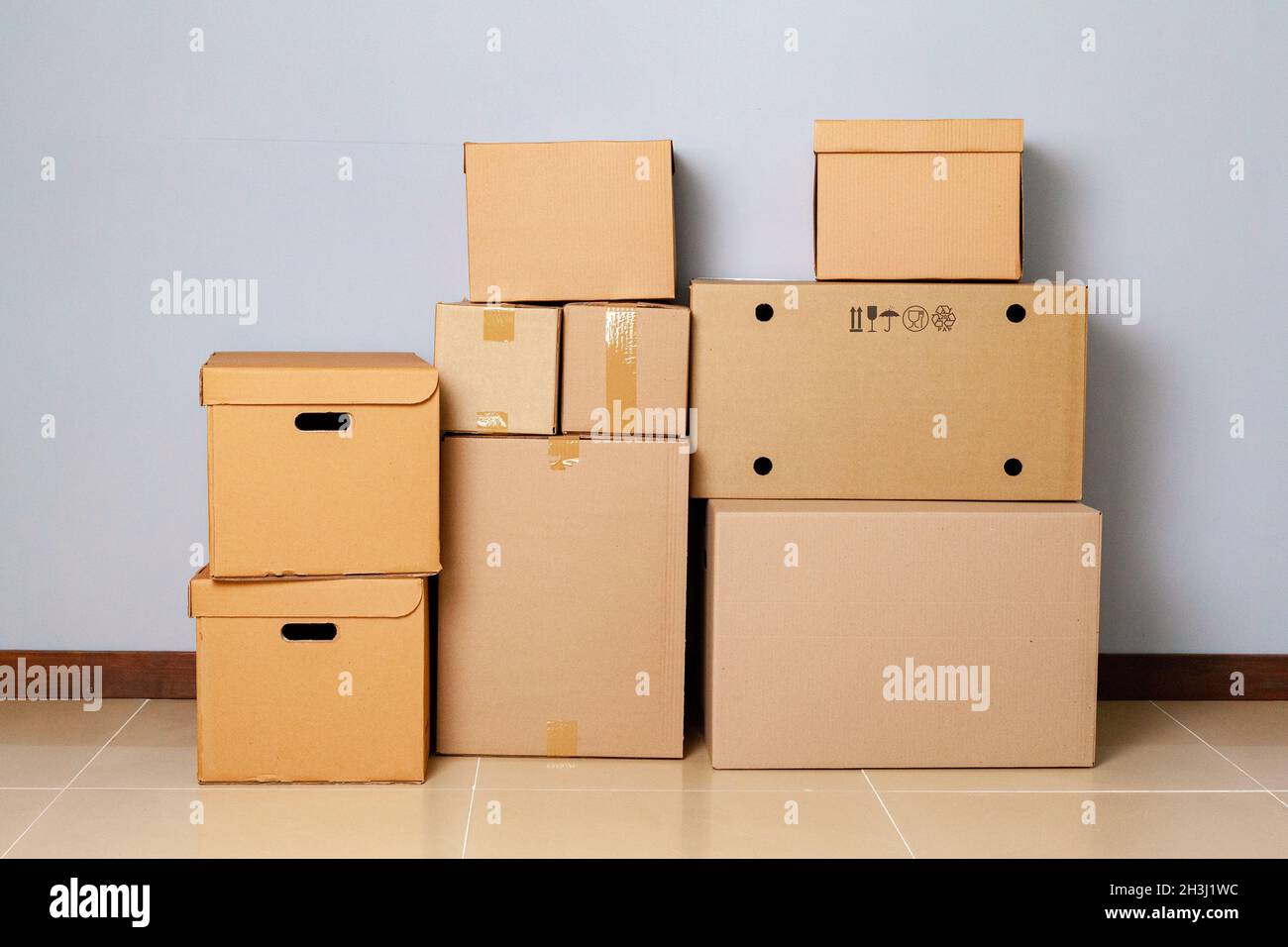 Cardboard boxes for moving on the floor against grey wall Stock Photo ...