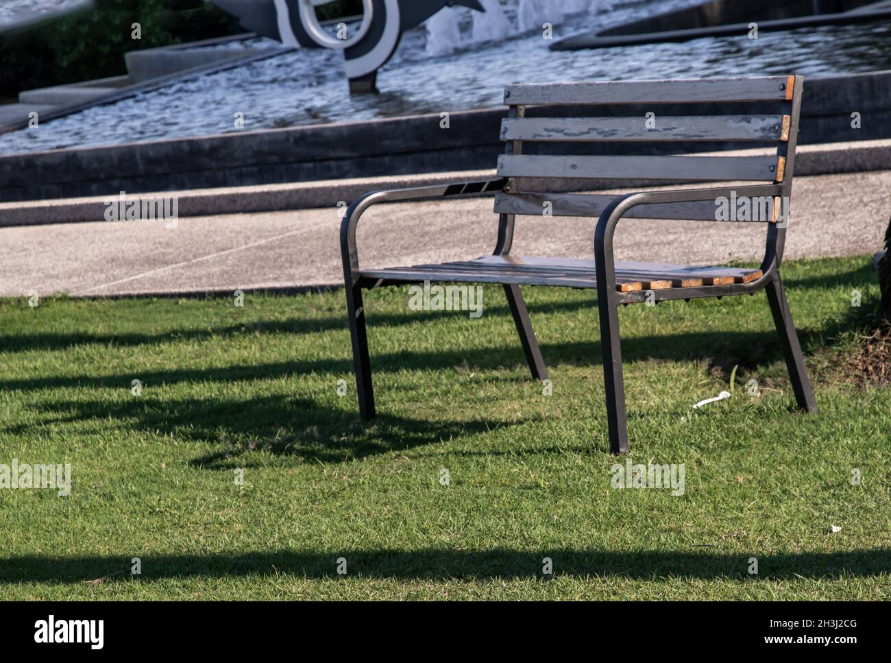 Wooden benches on grass floor in a shady area of the park. Seating and ...