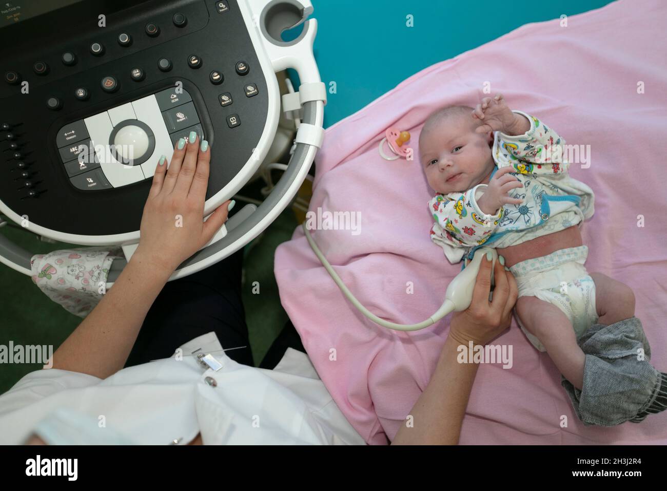 The doctor makes an ultrasound scan for a newborn baby.Medical exam of ...