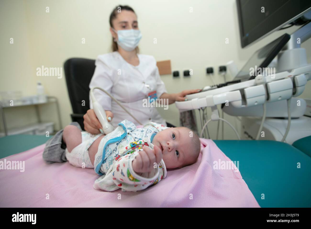 The doctor makes an ultrasound scan for a newborn baby.Medical exam of ...