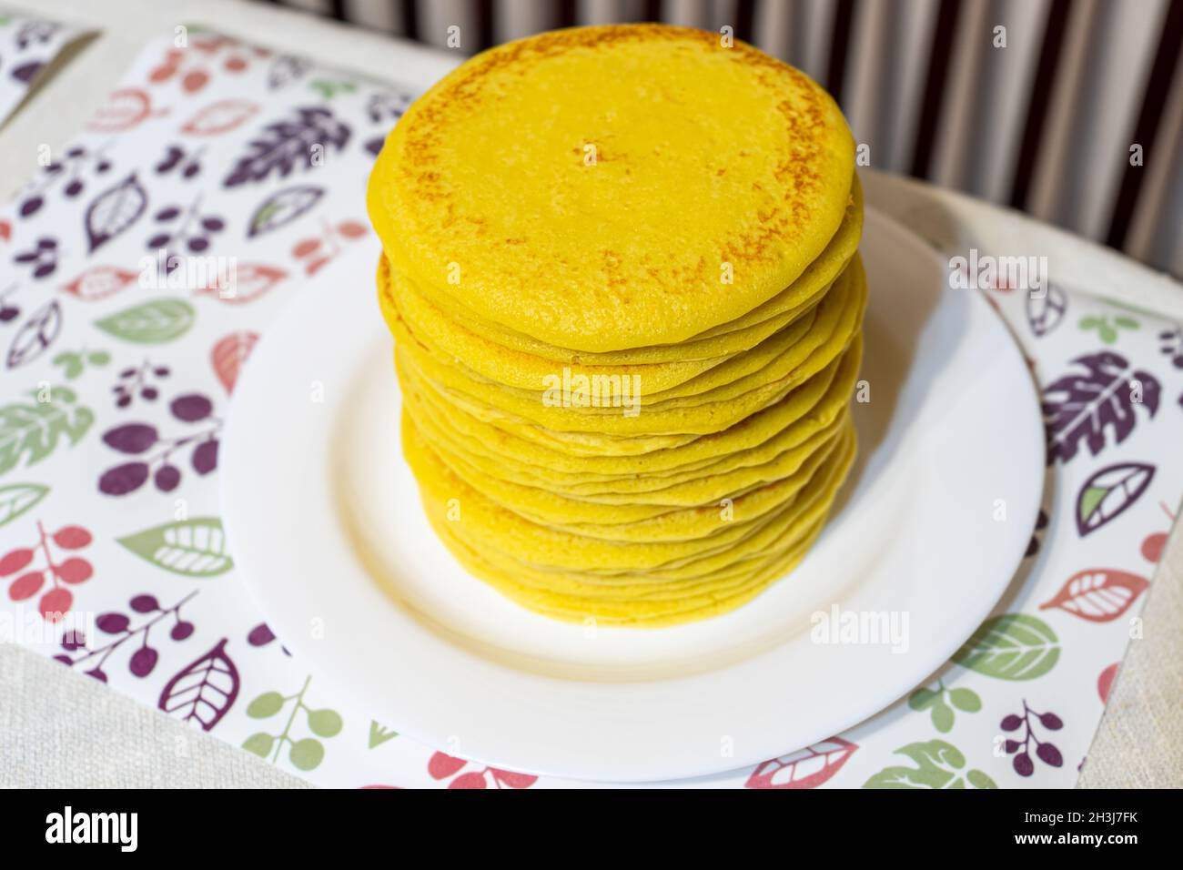 High stack of home-made pancakes on white plate. Breakfast for the ...