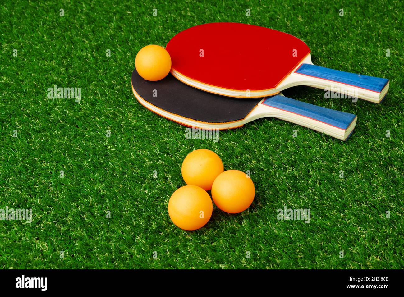 Ping pong rackets and ball on grass Stock Photo - Alamy