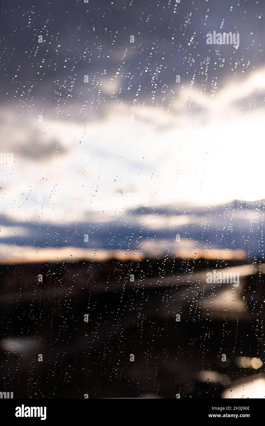 Raindrops on glass or window through which you can see the sky and ...
