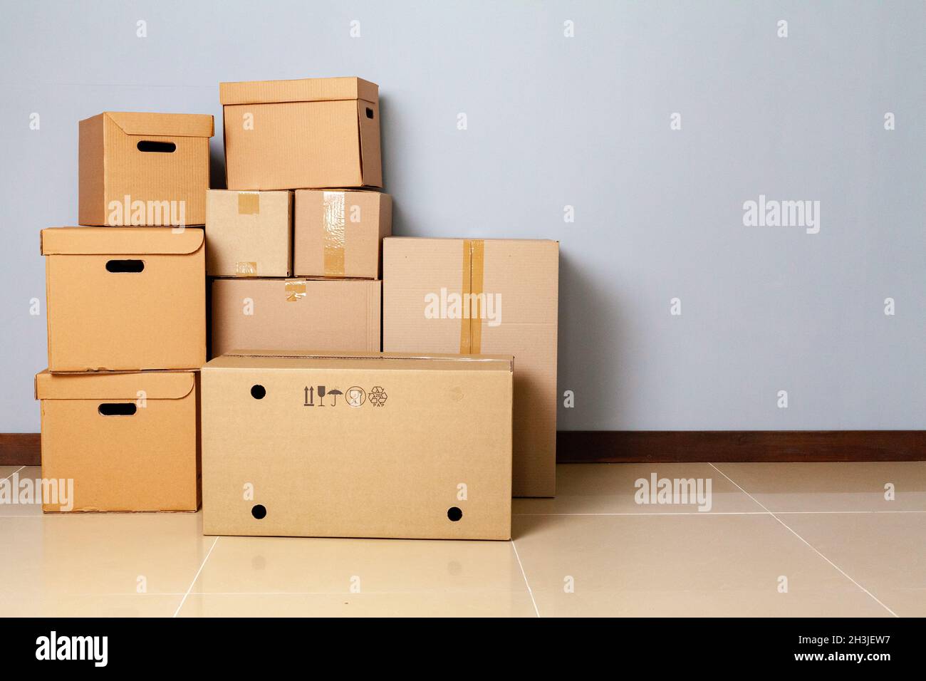 Cardboard boxes for moving on the floor against grey wall Stock Photo ...