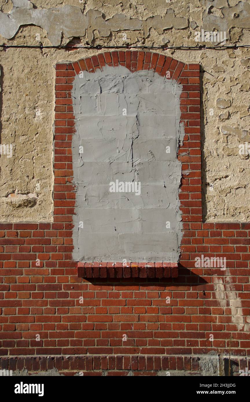 A bricked up window in an old building. A immured hole in a forgotten ...