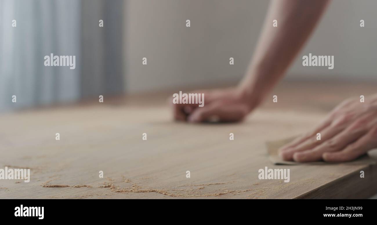 man hand sanding black walnut wood table, wide photo Stock Photo - Alamy