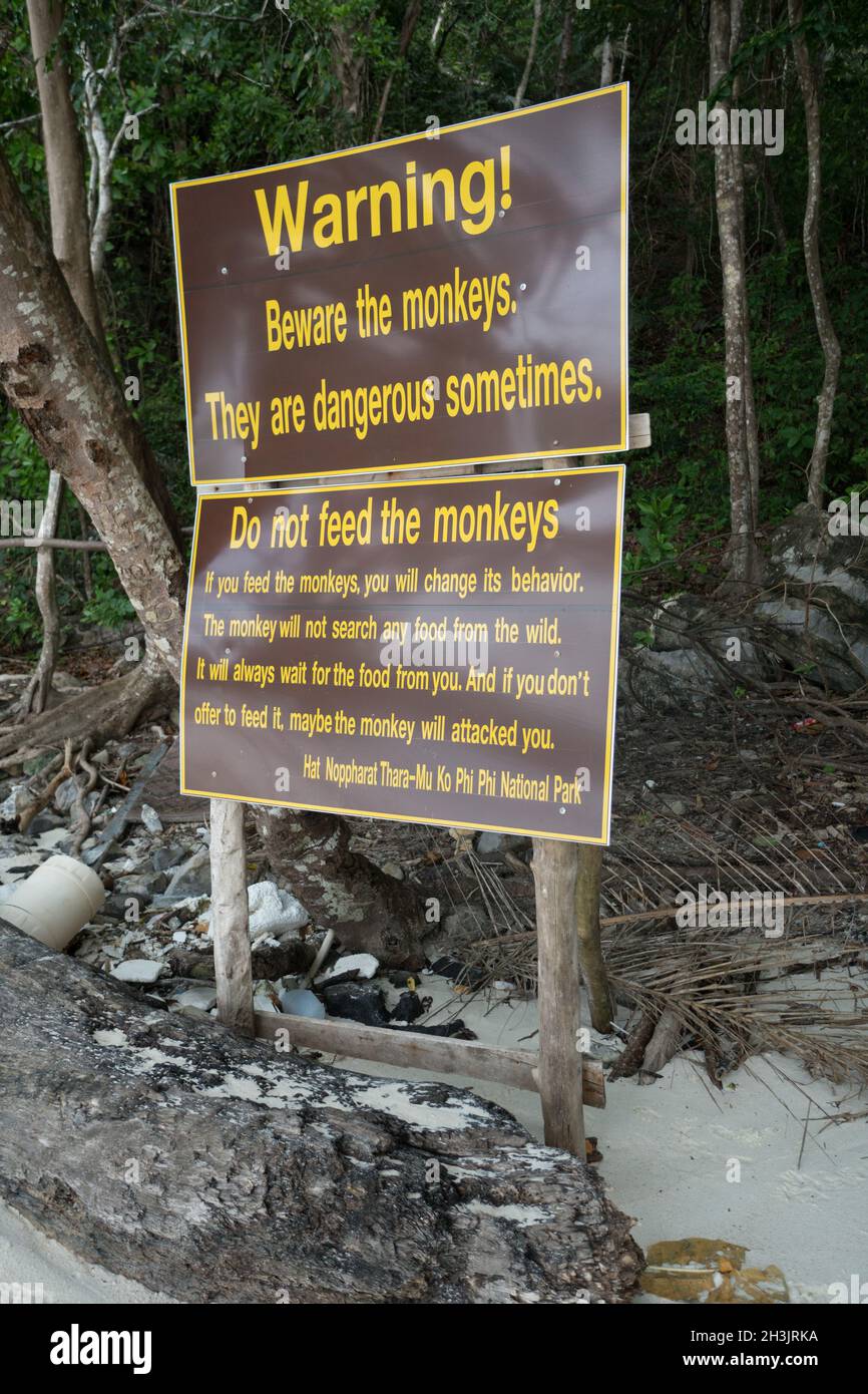 Beware of monkeys warning sign and others on a beach Stock Photo - Alamy