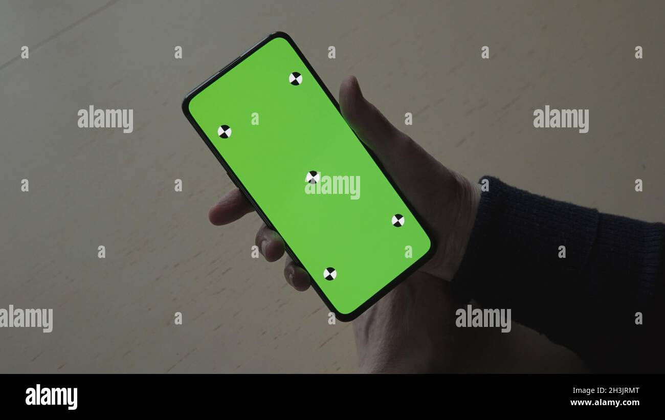 old female hands holding smartphone with green screen over wood vintage ...