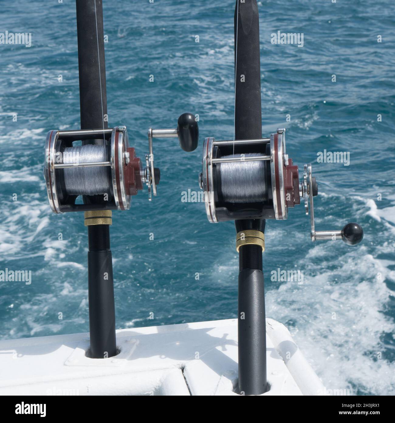 Fishing rods on a boat over blue sea Stock Photo - Alamy