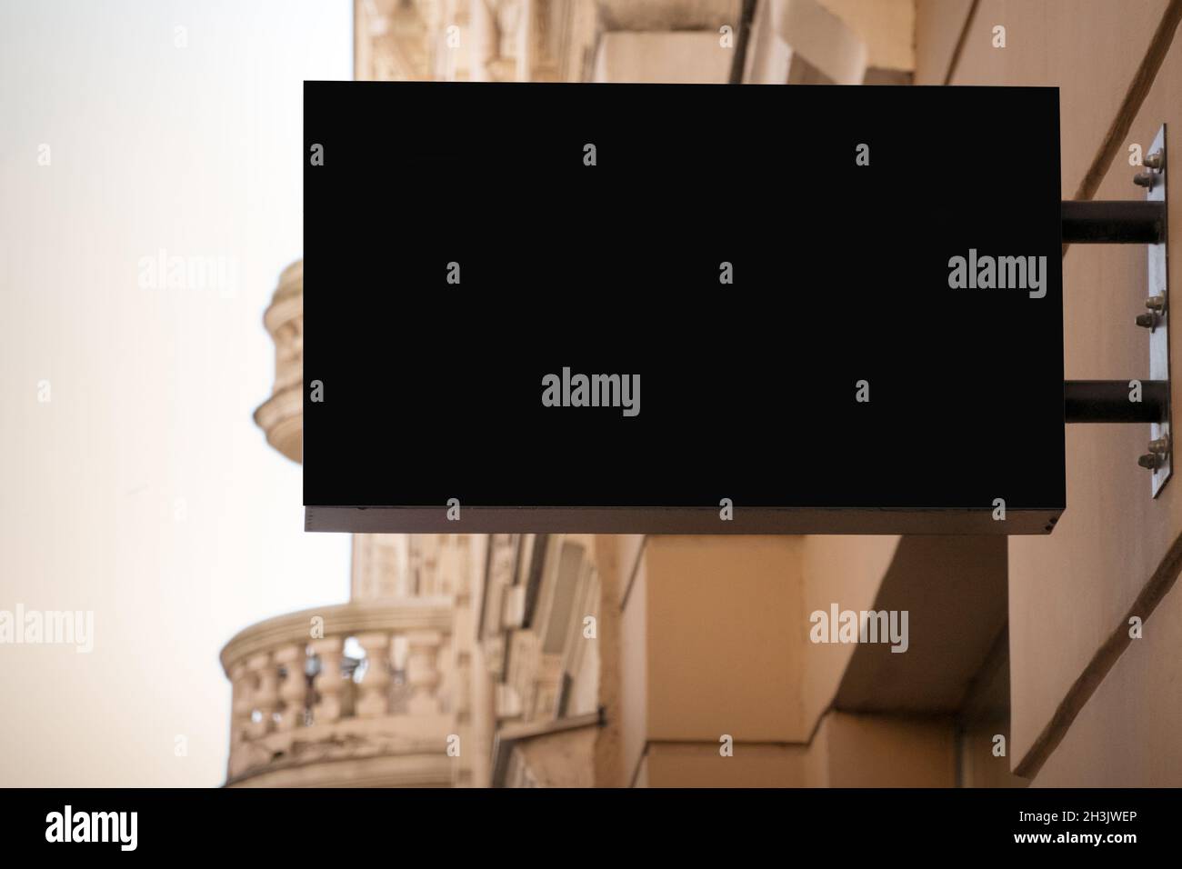 Mock up. Blank black rectangular shape signboard on the wall outdoors ...
