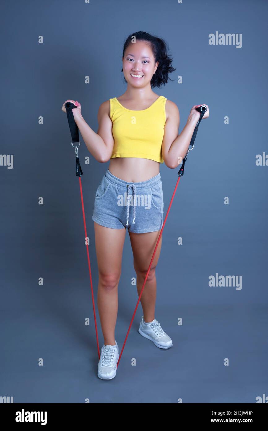 nice and smiling Chinese girl with rubber resistance bands Stock Photo ...