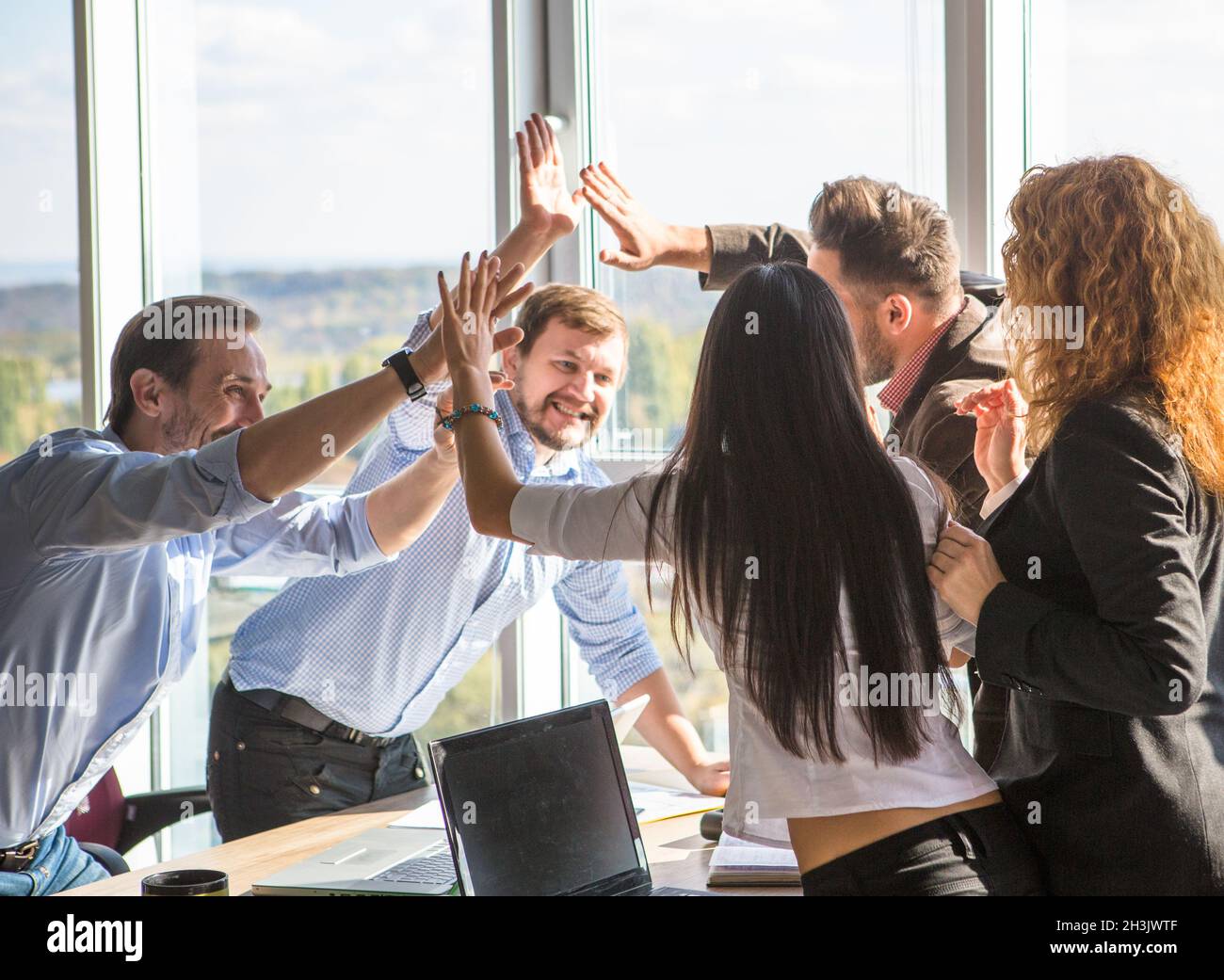 Business people showing team work in office Stock Photo - Alamy